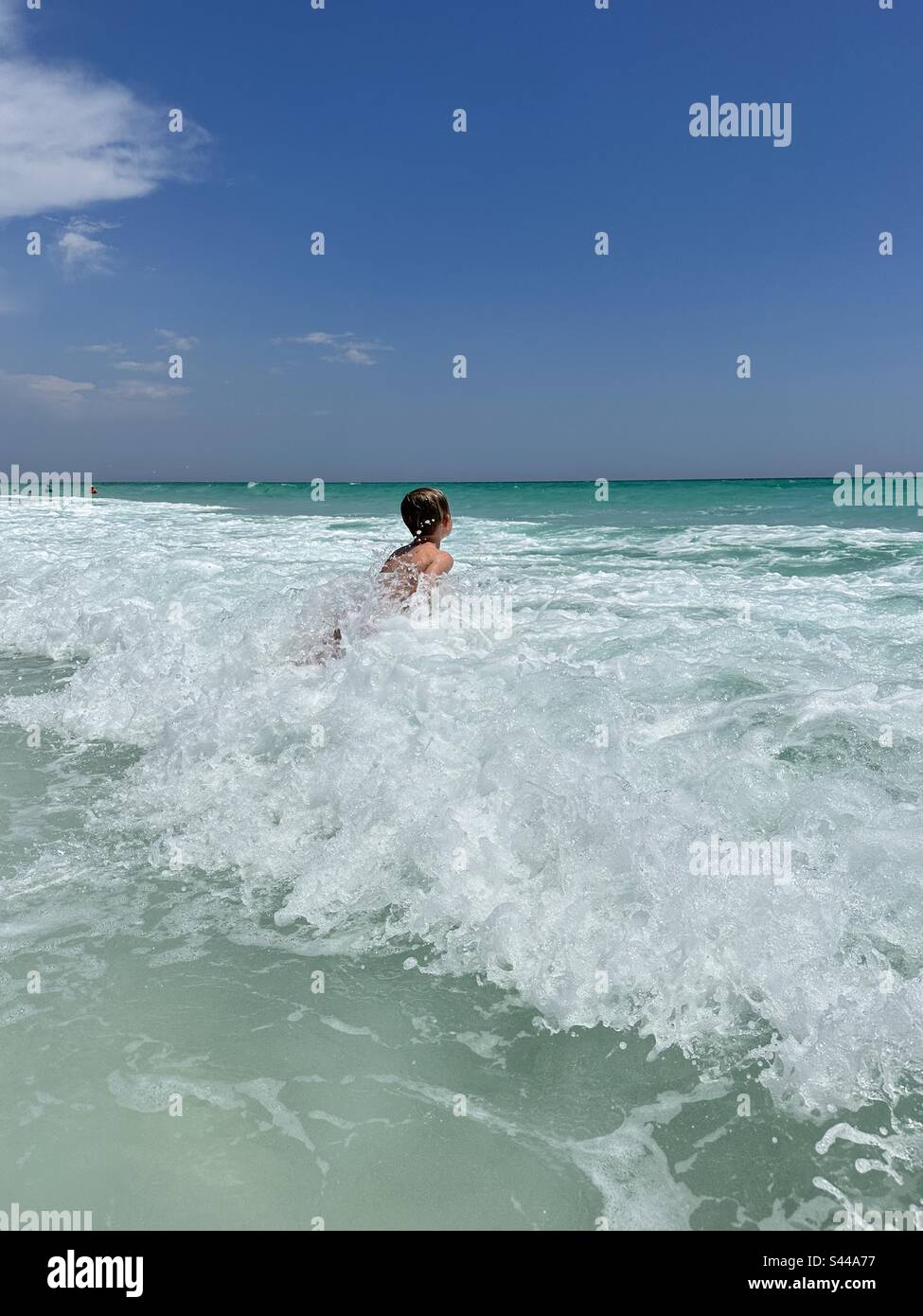 Young boy swimming in waves on the beach Stock Photo - Alamy