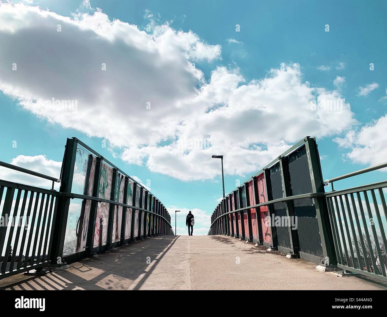 Tiny human silhouette walking by geometric bridge Stock Photo - Alamy