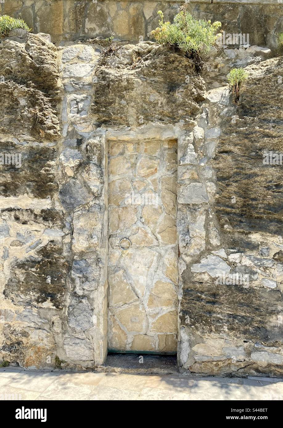 Stone door neatly hidden in a rock wall in Portugal Stock Photo - Alamy