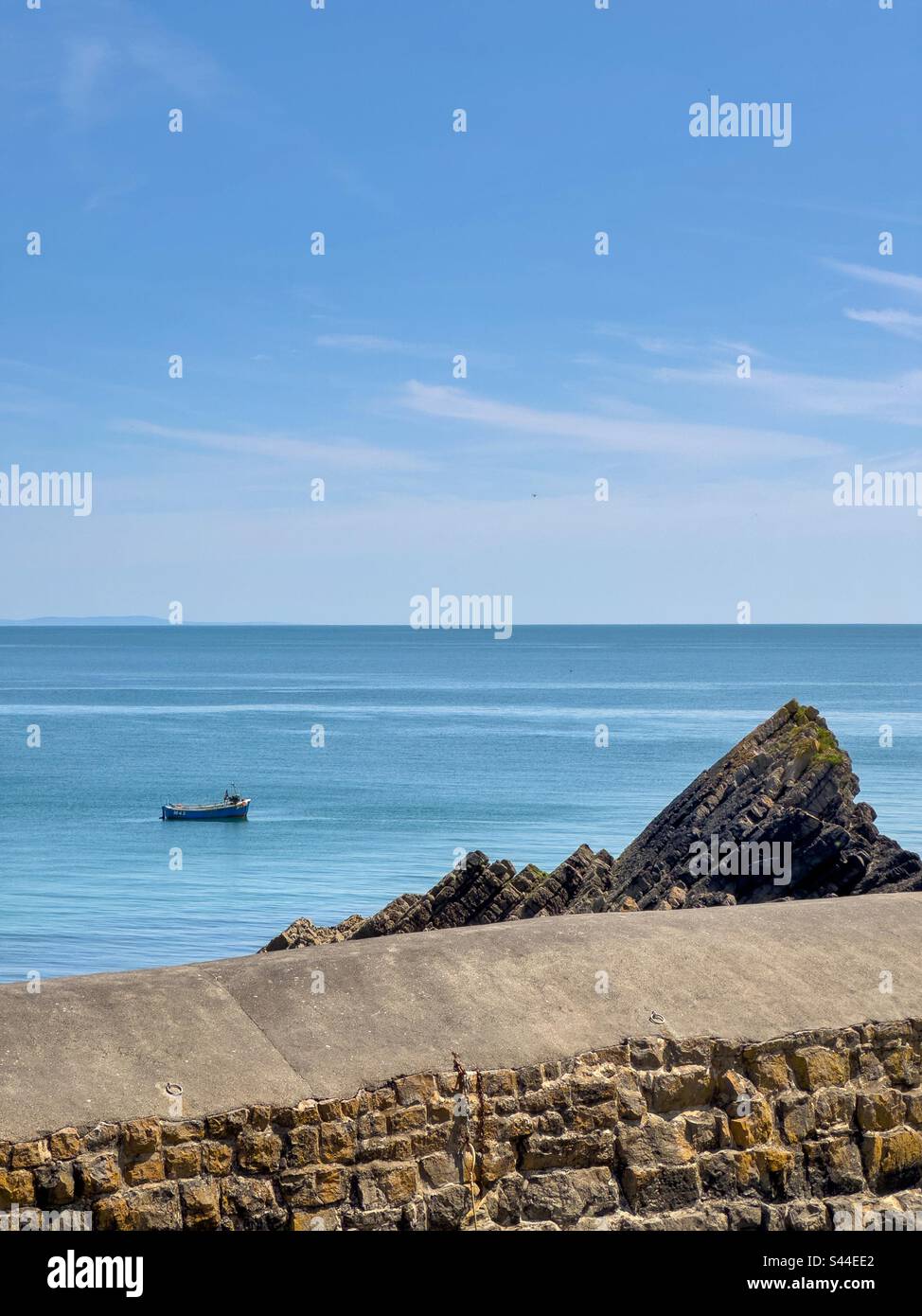 Boat and Rock. Stackpole Quay Stock Photo - Alamy