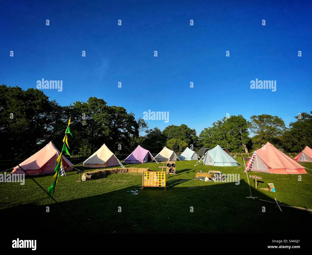 Multi-coloured bell tents are seen in a rural field ahead of a mini ...