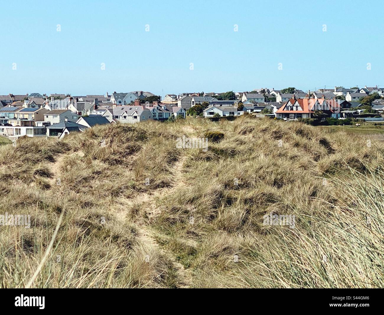 View across sand dunes towards Rhosneigr village, Anglesey, North Wales ...