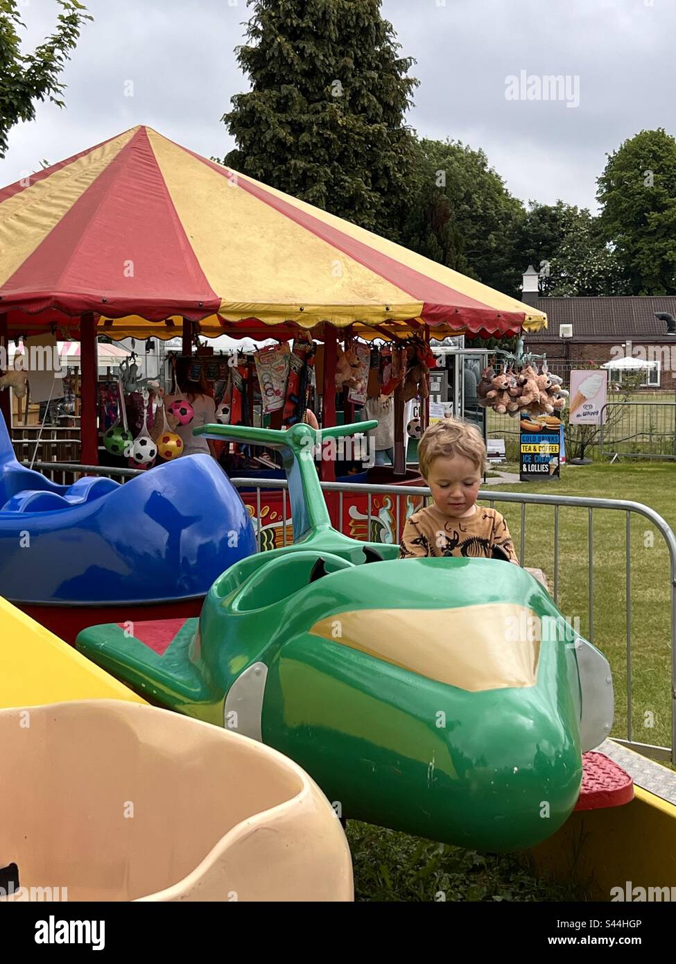 Youngblood haired boy riding a green rocket at the fair Stock Photo - Alamy
