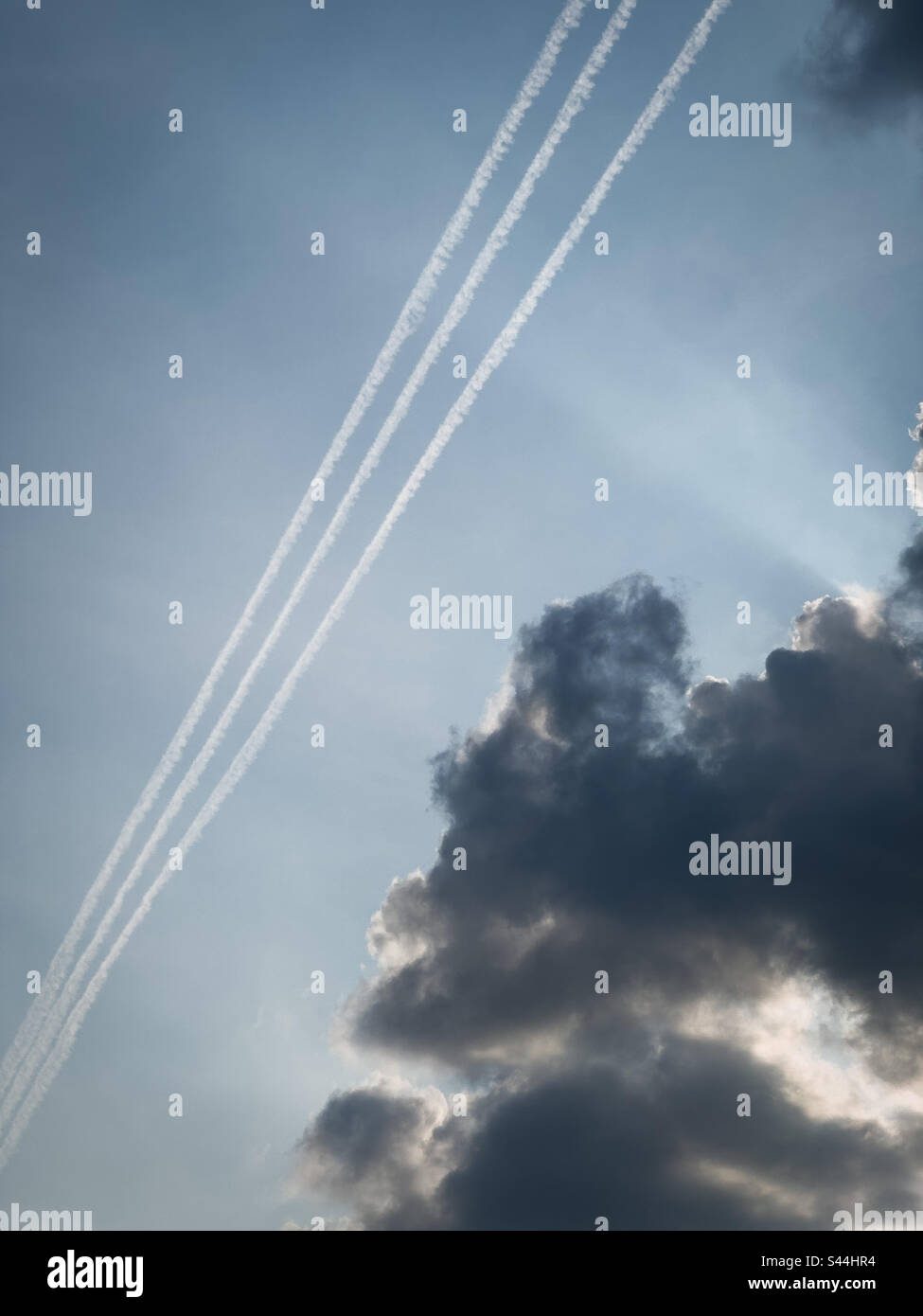 Triple vapour trails in the sky overhead in the early evening Stock ...
