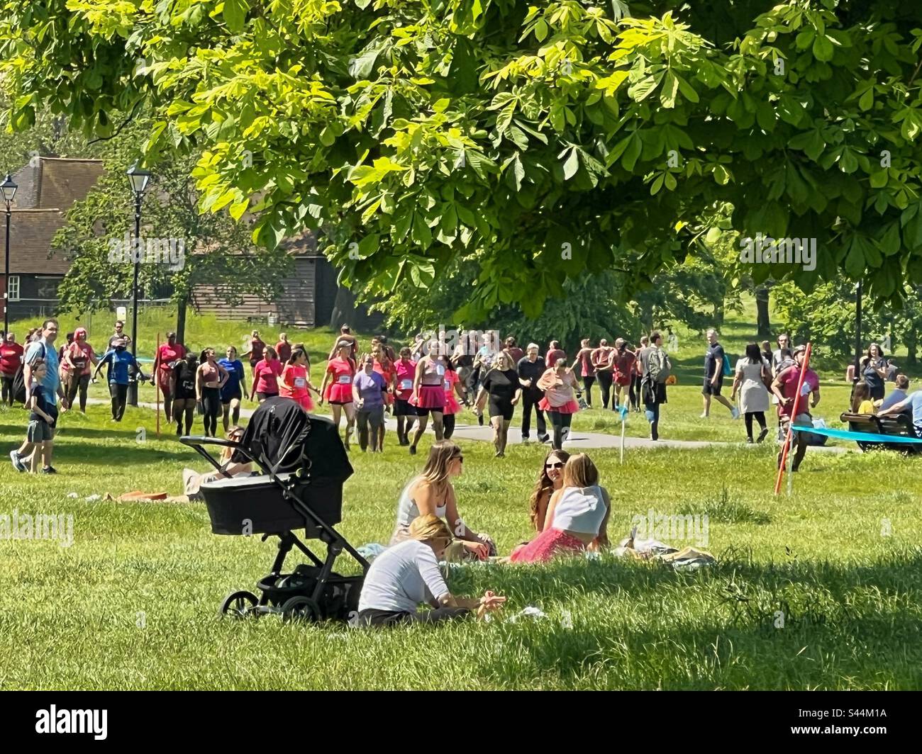 Young mothers with pram watch the Clapham common sponsored fun run ...