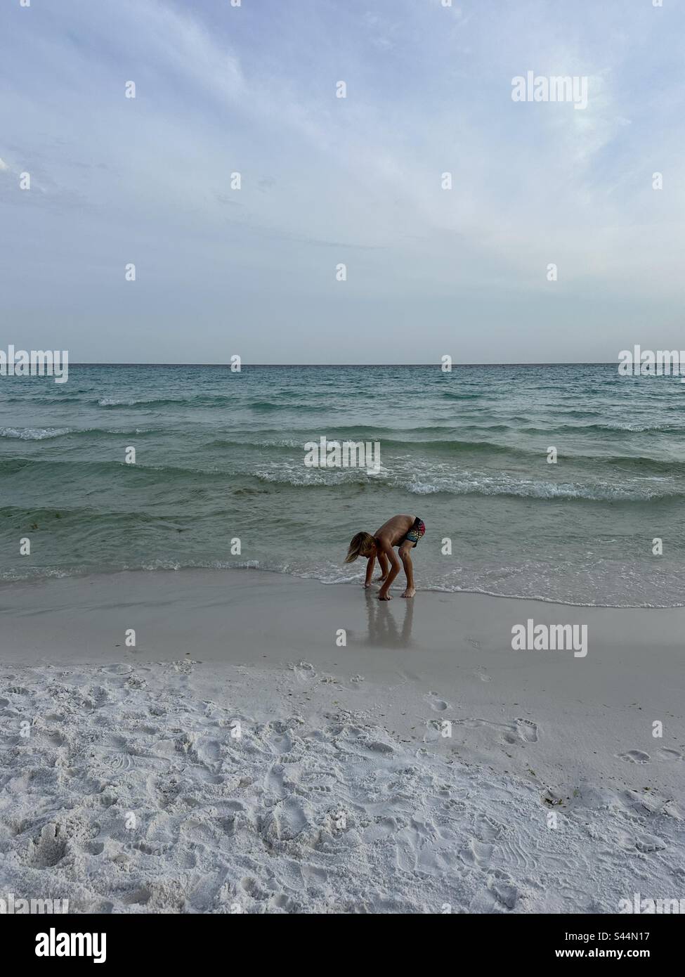 Young boy playing in the sand at sunset on Emerald Coast Florida beach ...