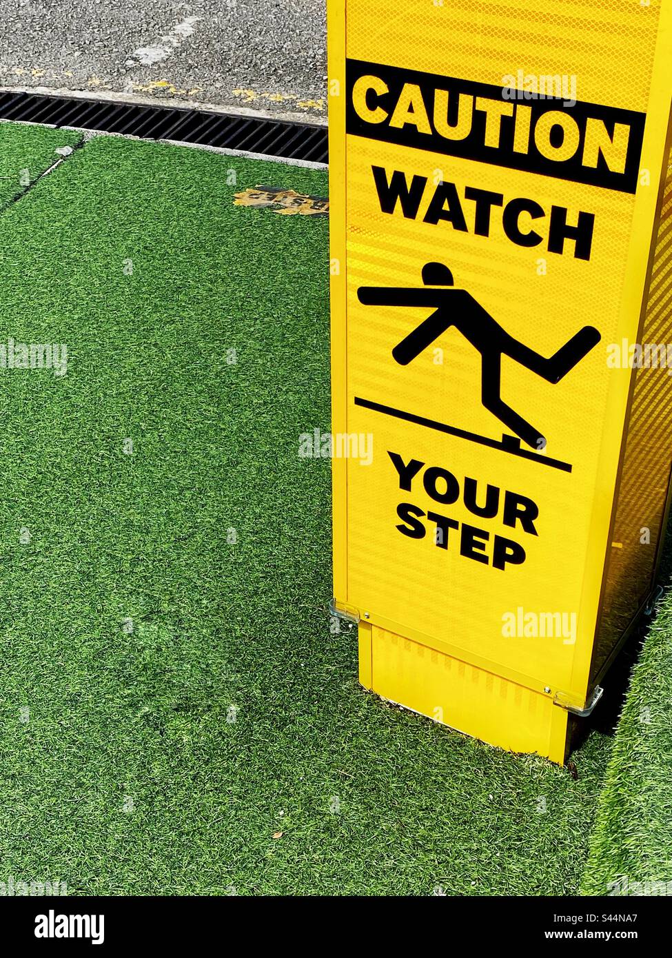 Yellow caution sign, watch your step Stock Photo - Alamy