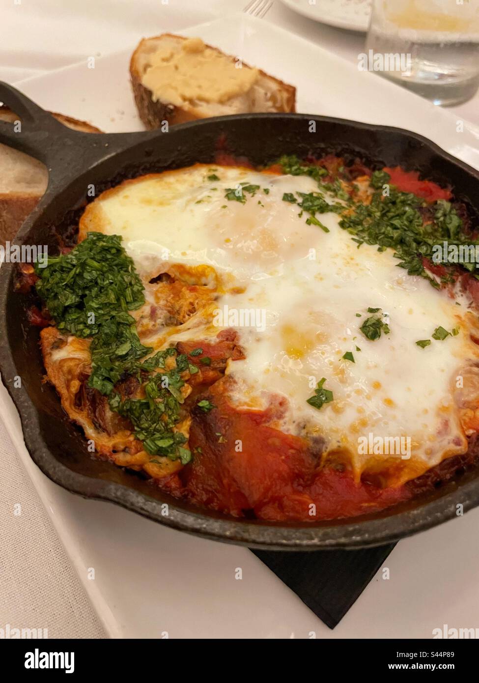 Skillet breakfast of short rib hash, baked eggs and spicy salsa at a ...