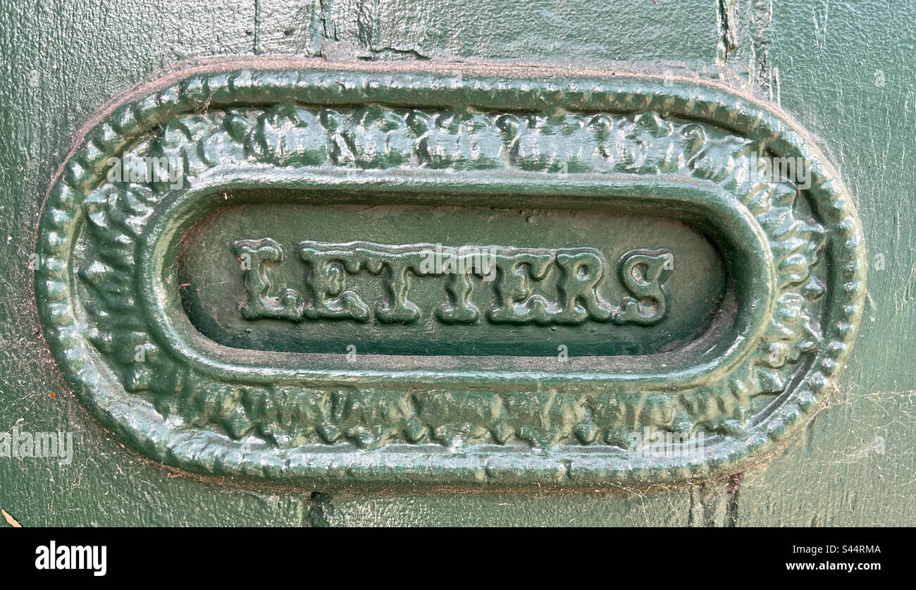 Old style letter slot on a green door Stock Photo - Alamy