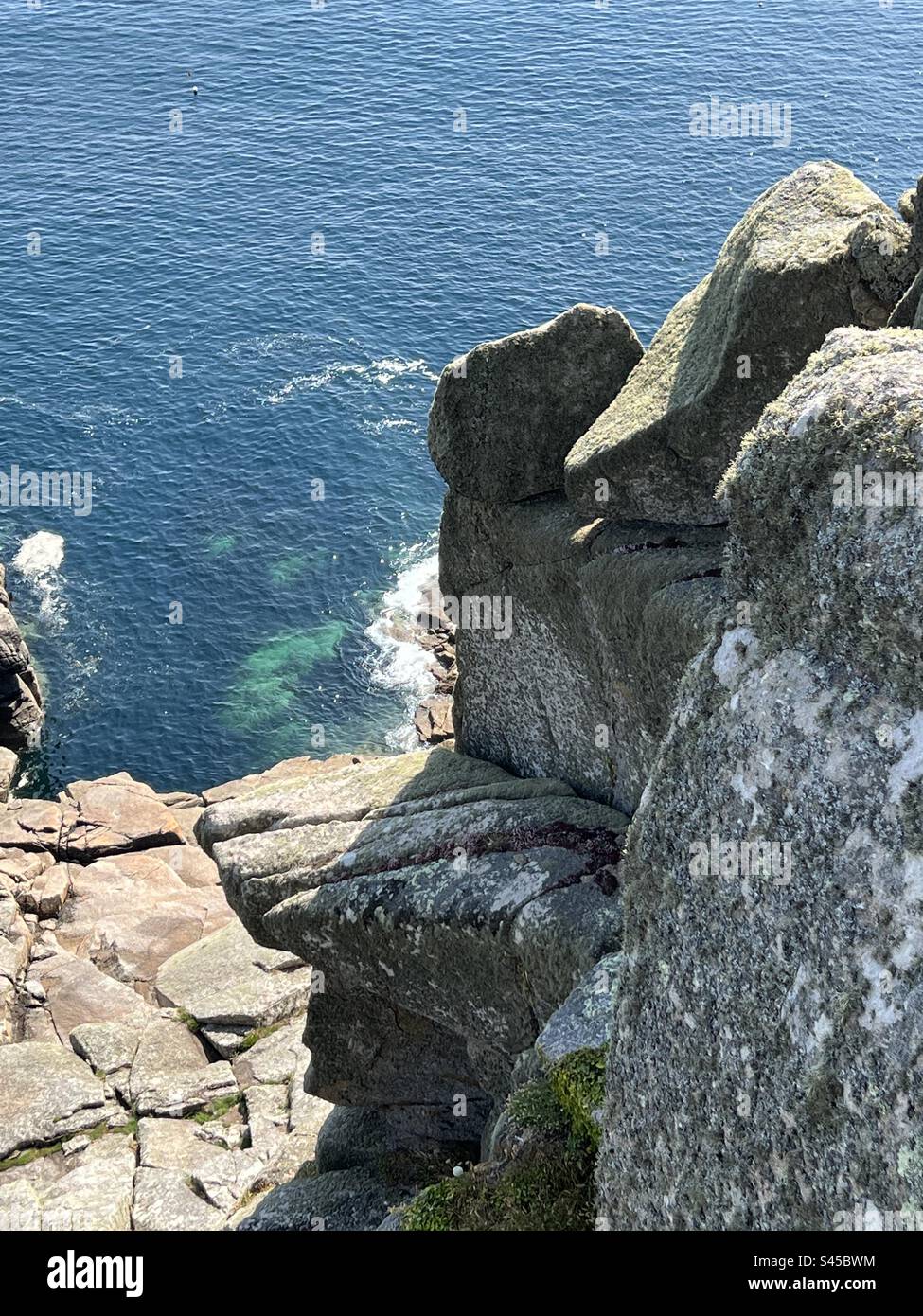 Rocky cliff and blue ocean below off the Cornish coast in summer Stock ...