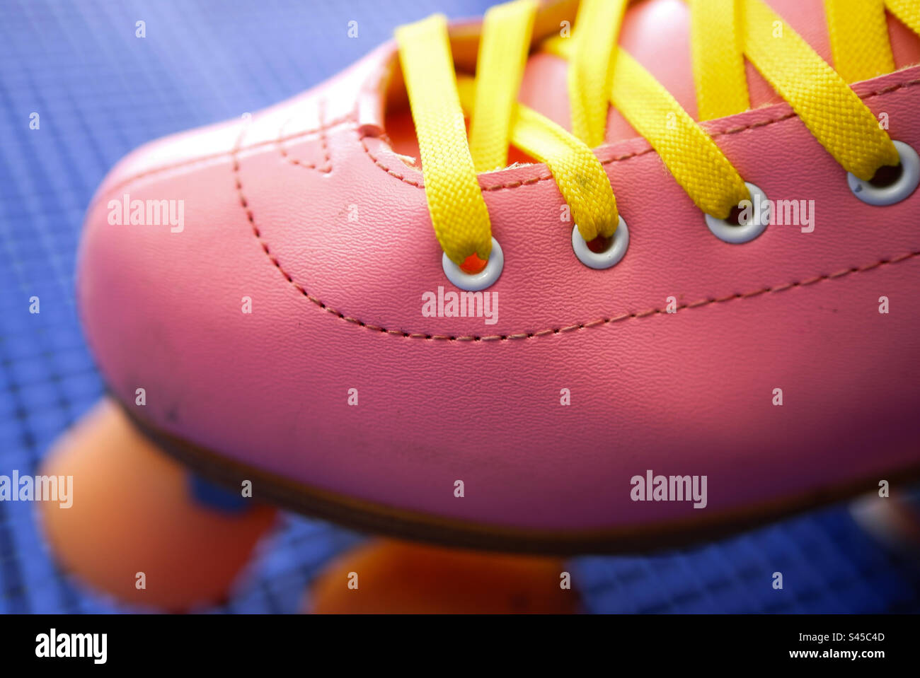Pink roller skates with yellow laces Stock Photo - Alamy
