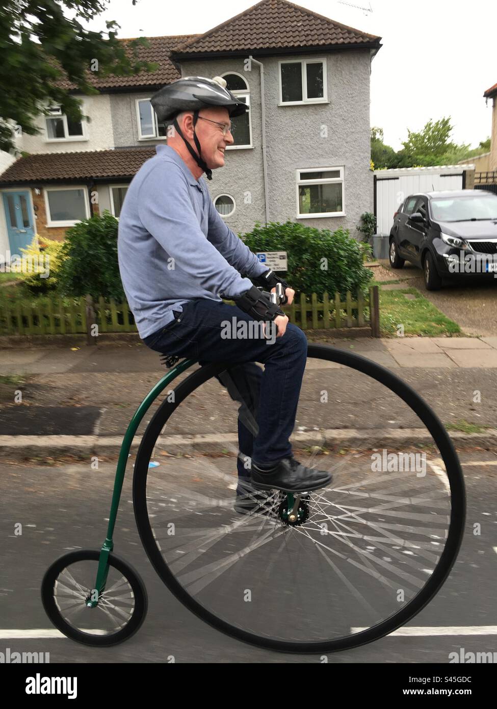 Man riding a Penny-farthing, or ‘Ordinary’, bicycle in a suburban ...