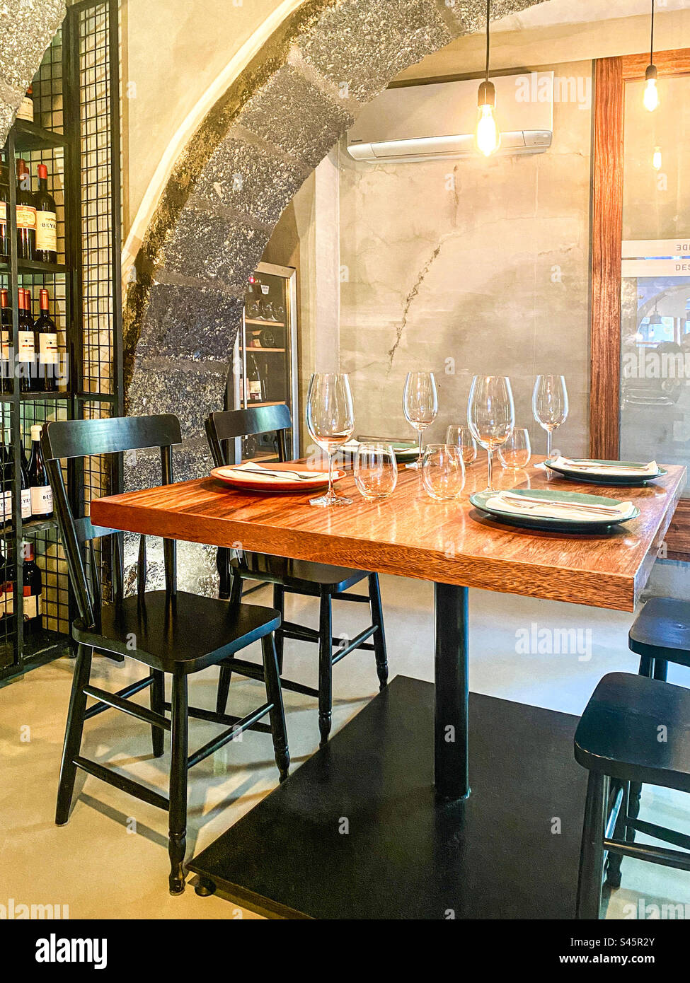 Restaurant table set and ready to seat patrons. Wine racks for n ...