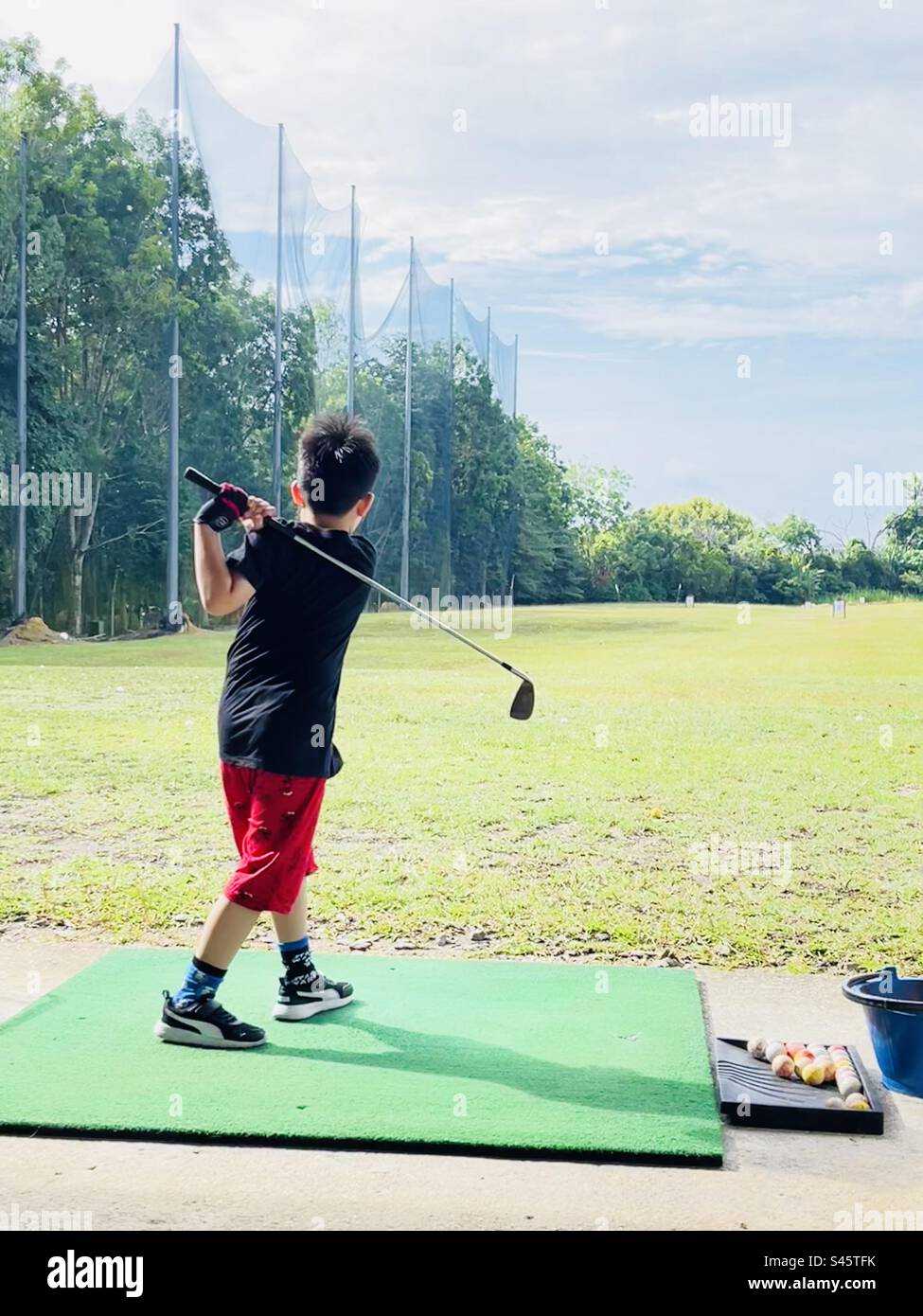 Kids golf at driving range Stock Photo - Alamy