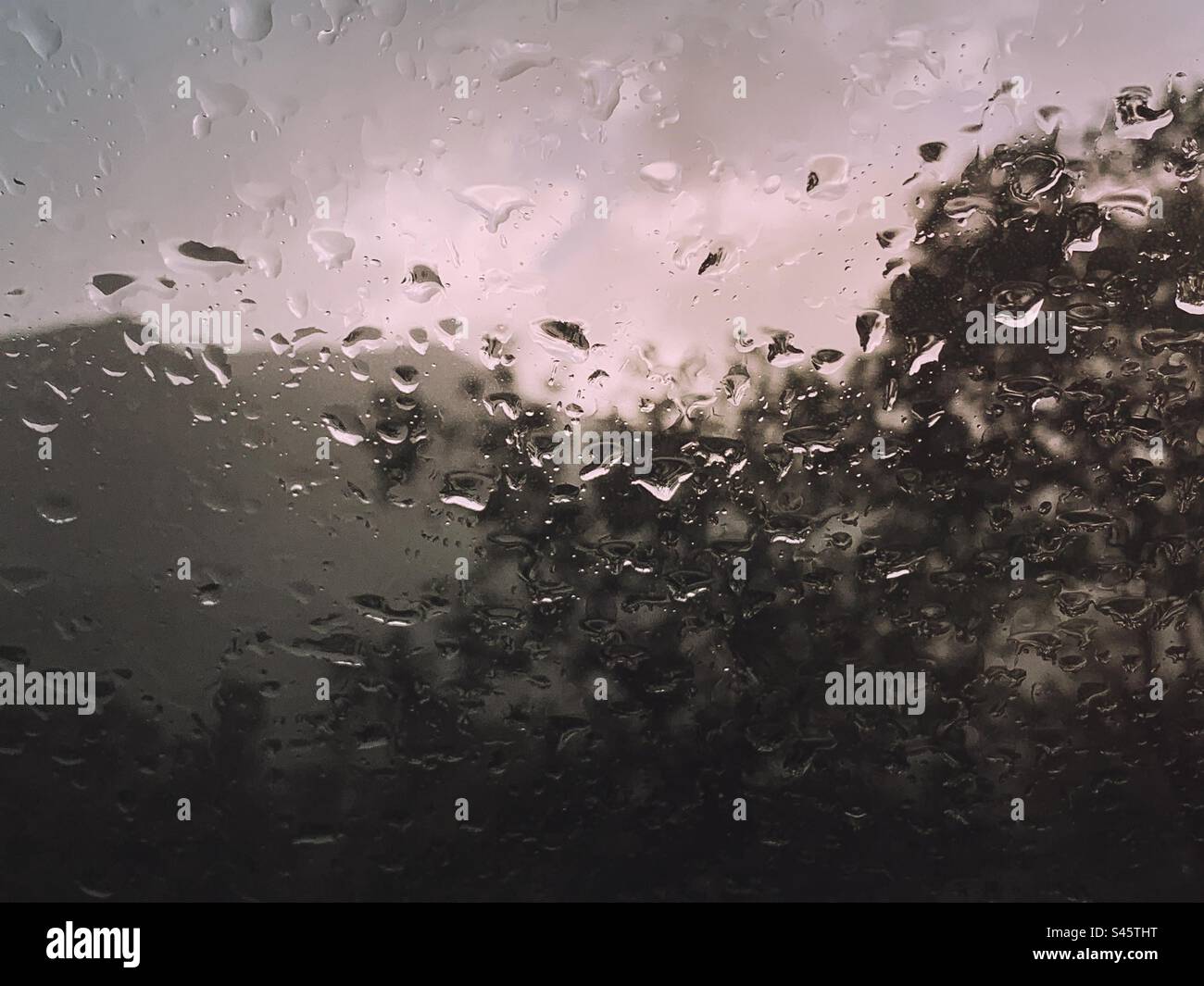 A wet window with raindrops and a trek and sky background - rain ...