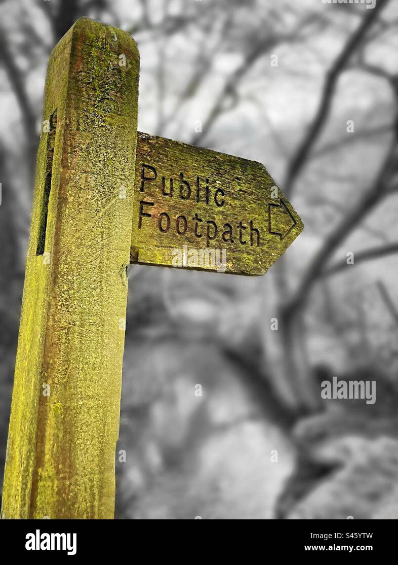A moss covered Public Footpath signpost with black and white ...