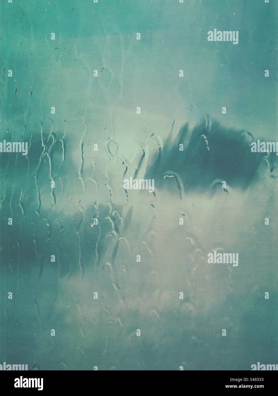 A wet glass window with rain and clouds weather background Stock Photo ...