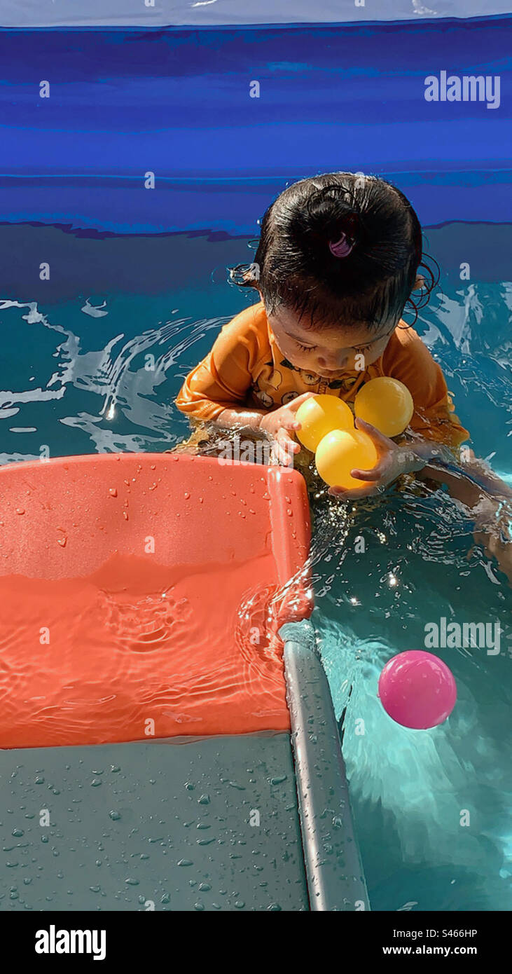 Toddler playing ball in pool Stock Photo - Alamy