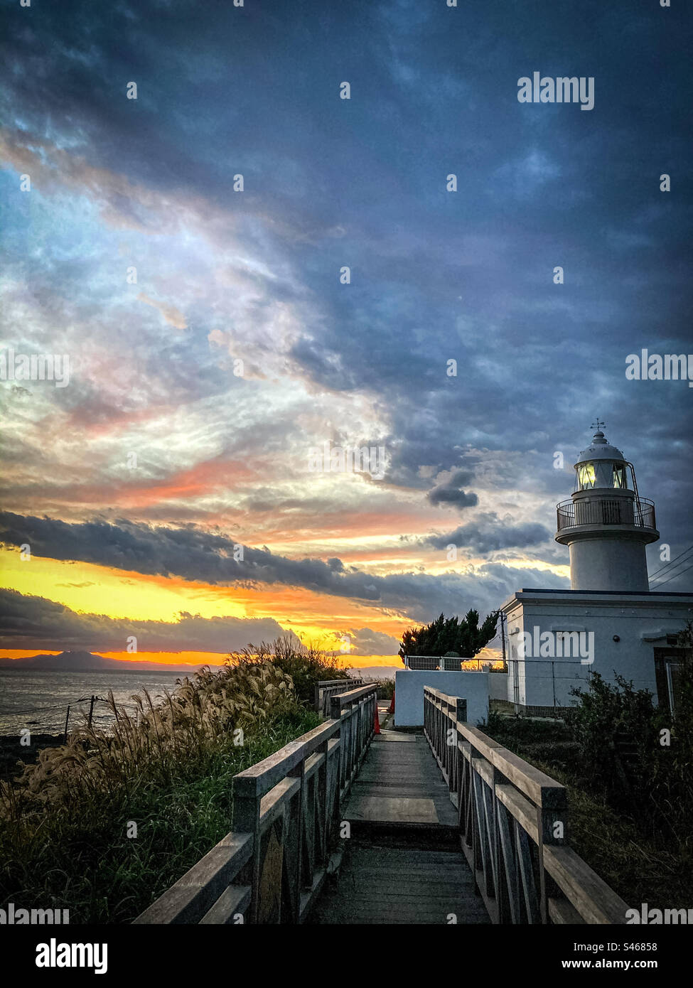 A lighthouse in operation. The sun is setting in the West Stock Photo ...