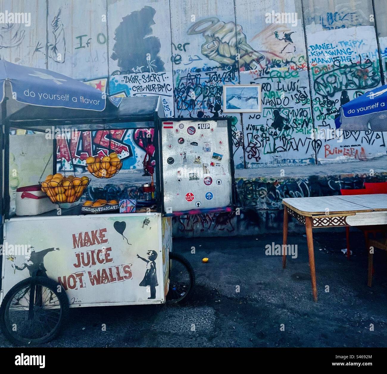 A juice vendor by the Israeli security barrier in Bethlehem, Palestine ...
