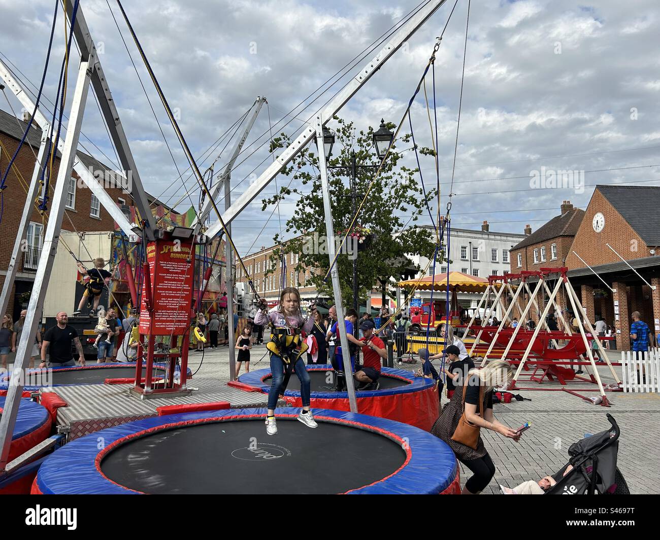 Fairground in the village square, England, July 2023. Carnival rides ...