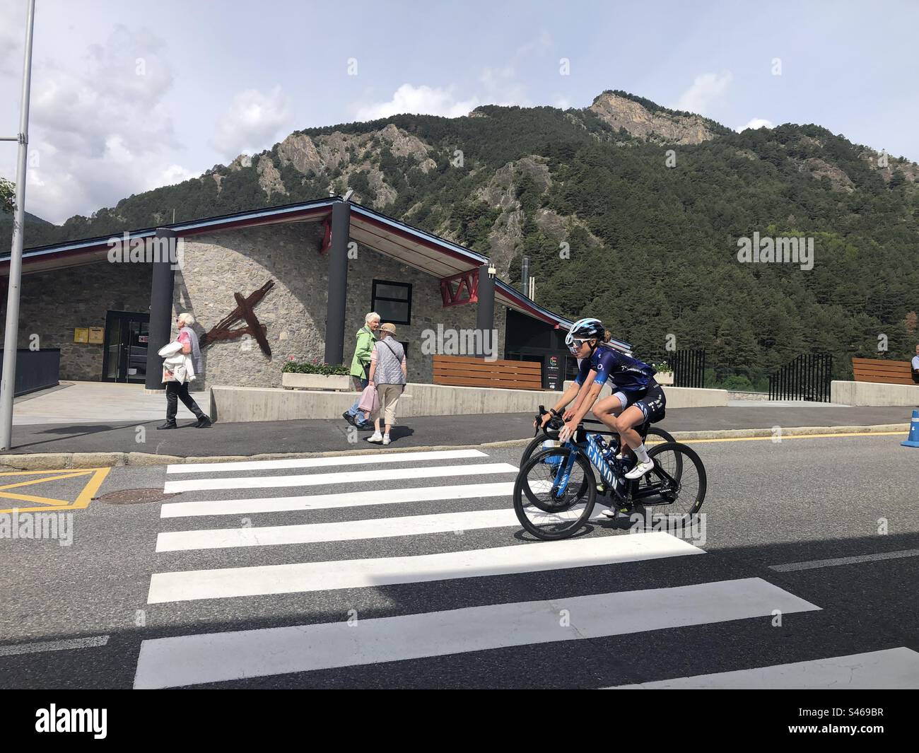 Sports Cyclists crossing zebra crossing with mountain in background ...