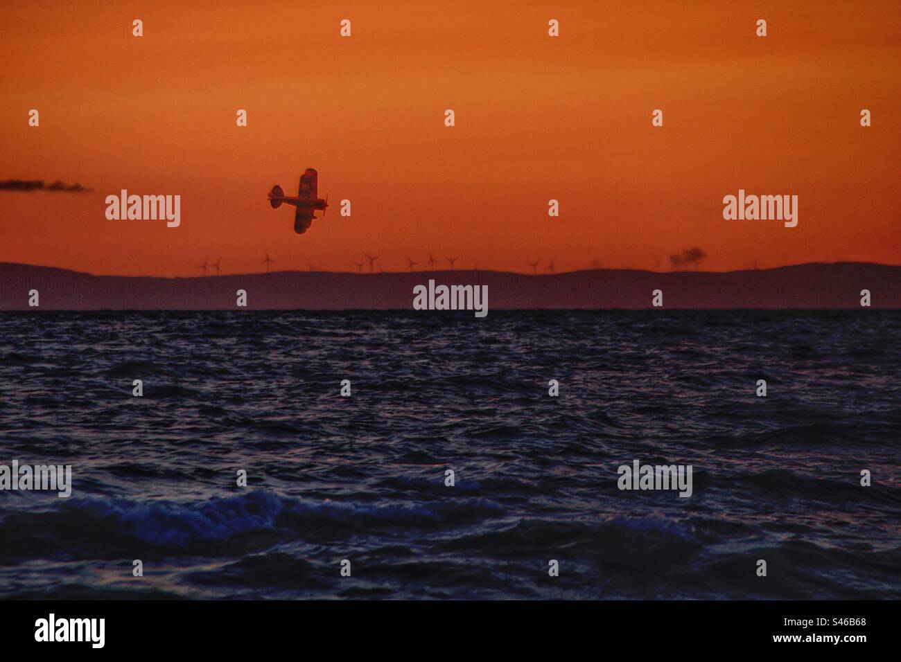 Bi-plane over the Irish Sea at dusk Stock Photo - Alamy