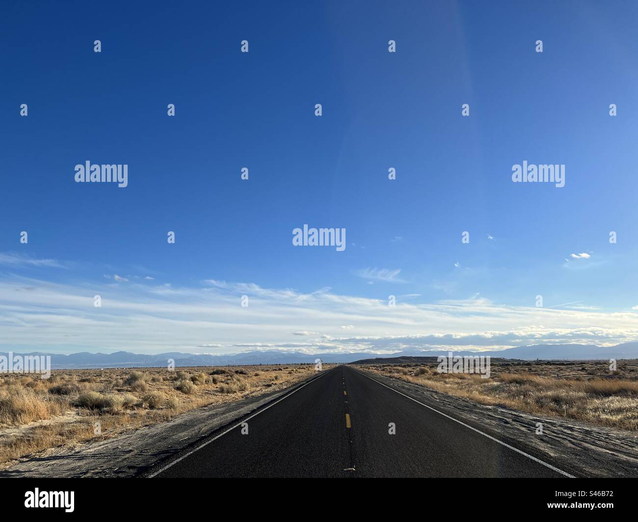 High viewpoint with black asphalt low in frame, with bright yellow ...