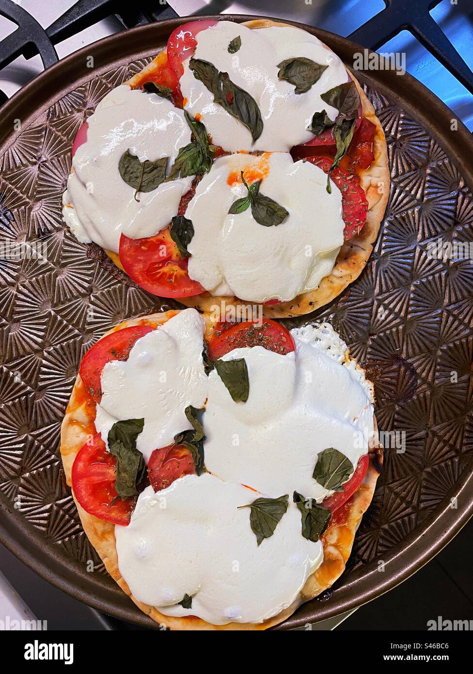 Homemade flatbread pizzas, fresh out of the oven with melted mozzarella ...
