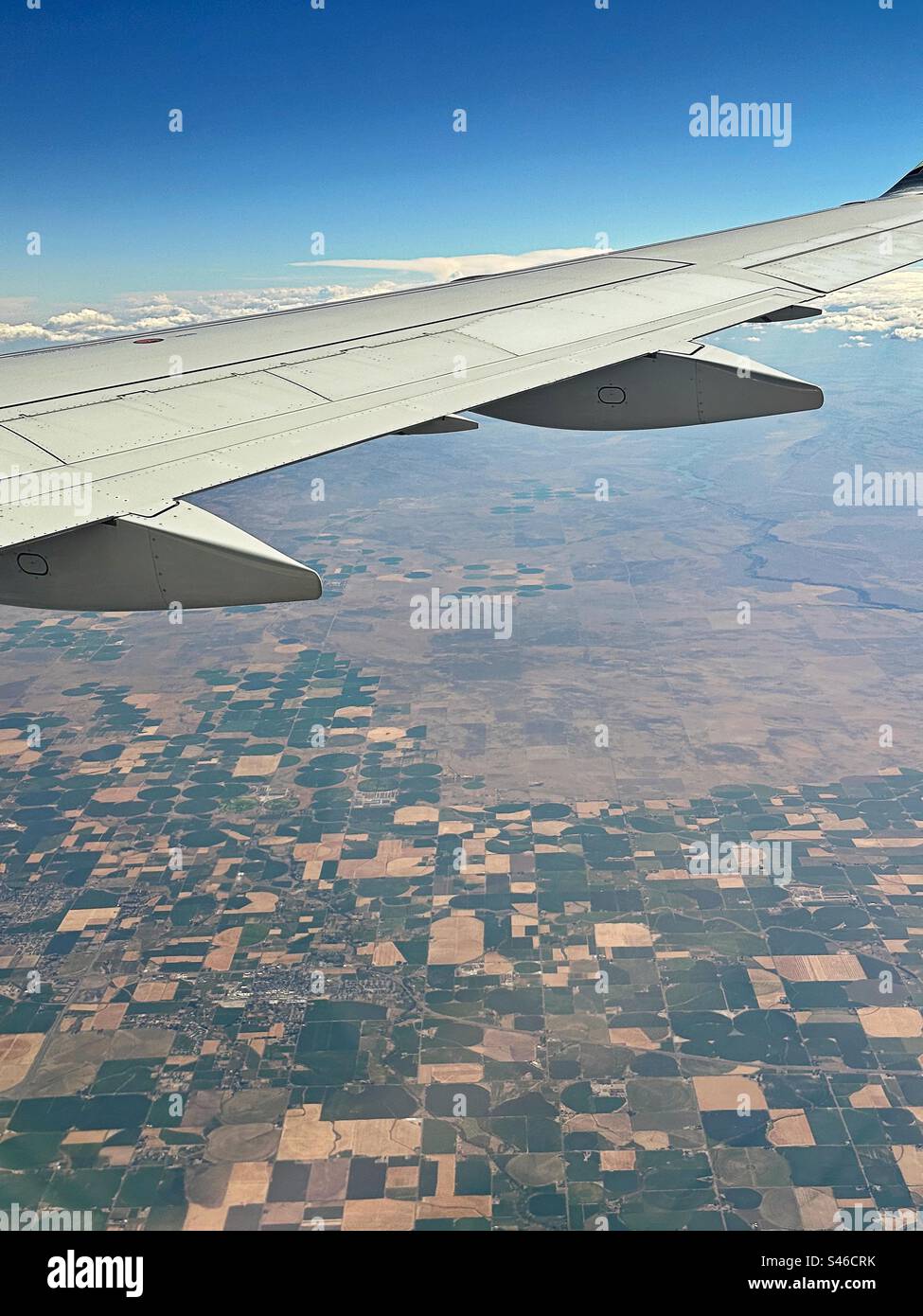 View from an airplane flying over farm lands and center pivot ...