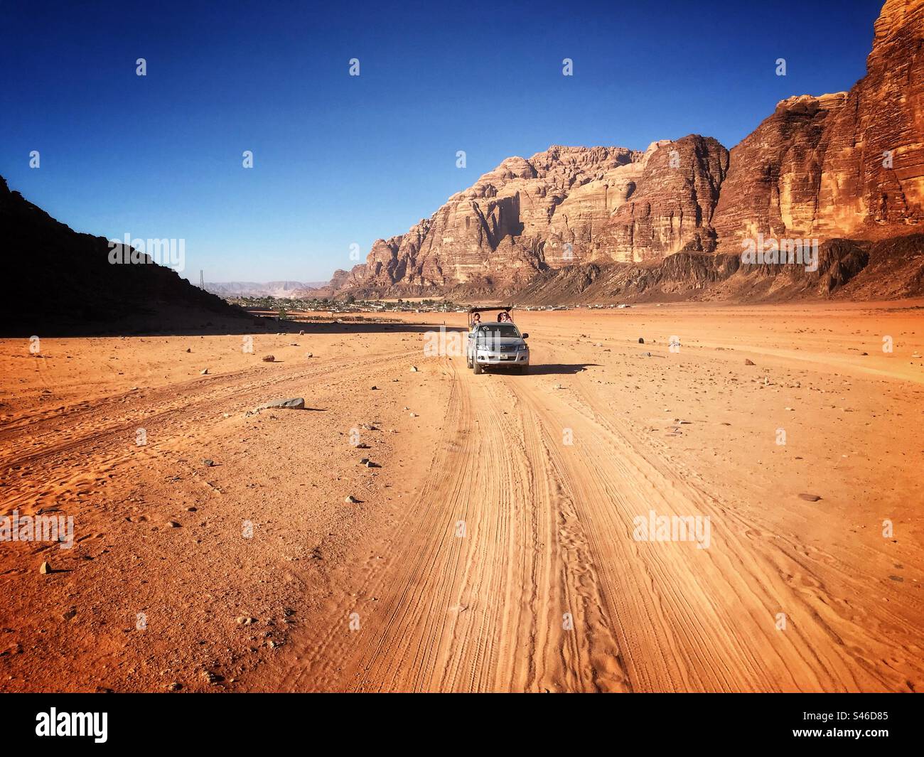Wadi Rum Jordan tourists travel on a 4WD vehicle through the vast ...