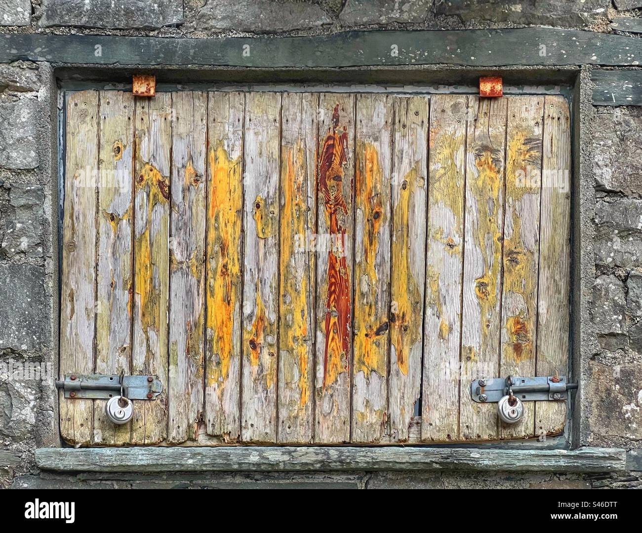 Locked wooden hatch with peeling paint set in stone wall Stock Photo ...