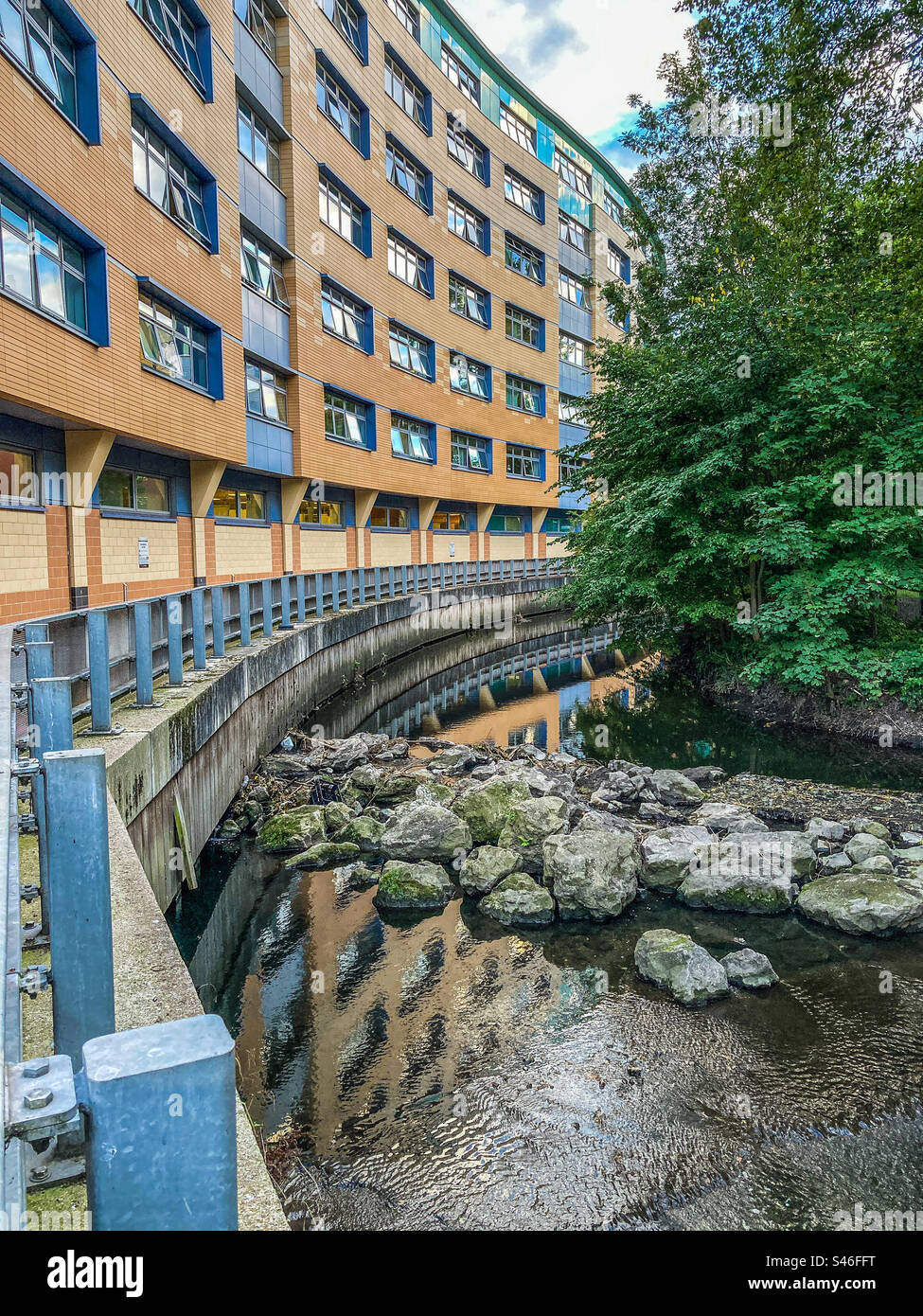 Riverside Wing of Lewisham Hospital reflected in the river Ravensbourne ...