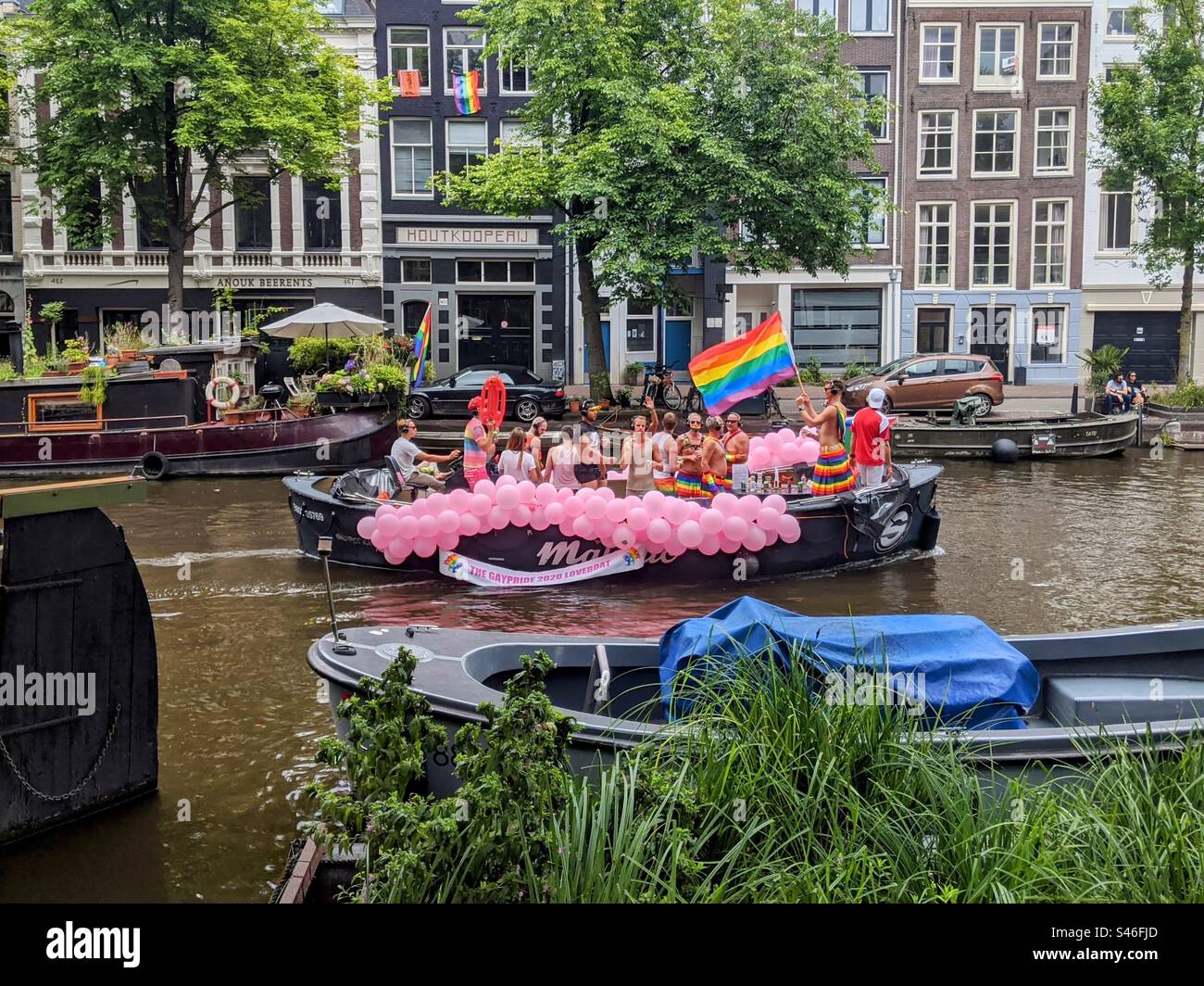 A boat floating on a dutch water canal in Amsterdam with crowd of ...