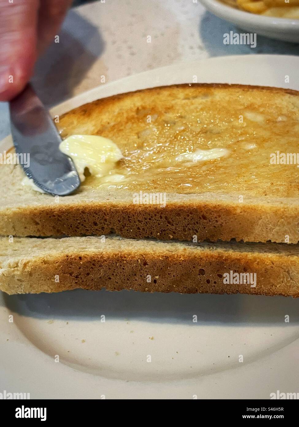 Man buttering rye toast at a diner, 2023, New York City, USA Stock ...
