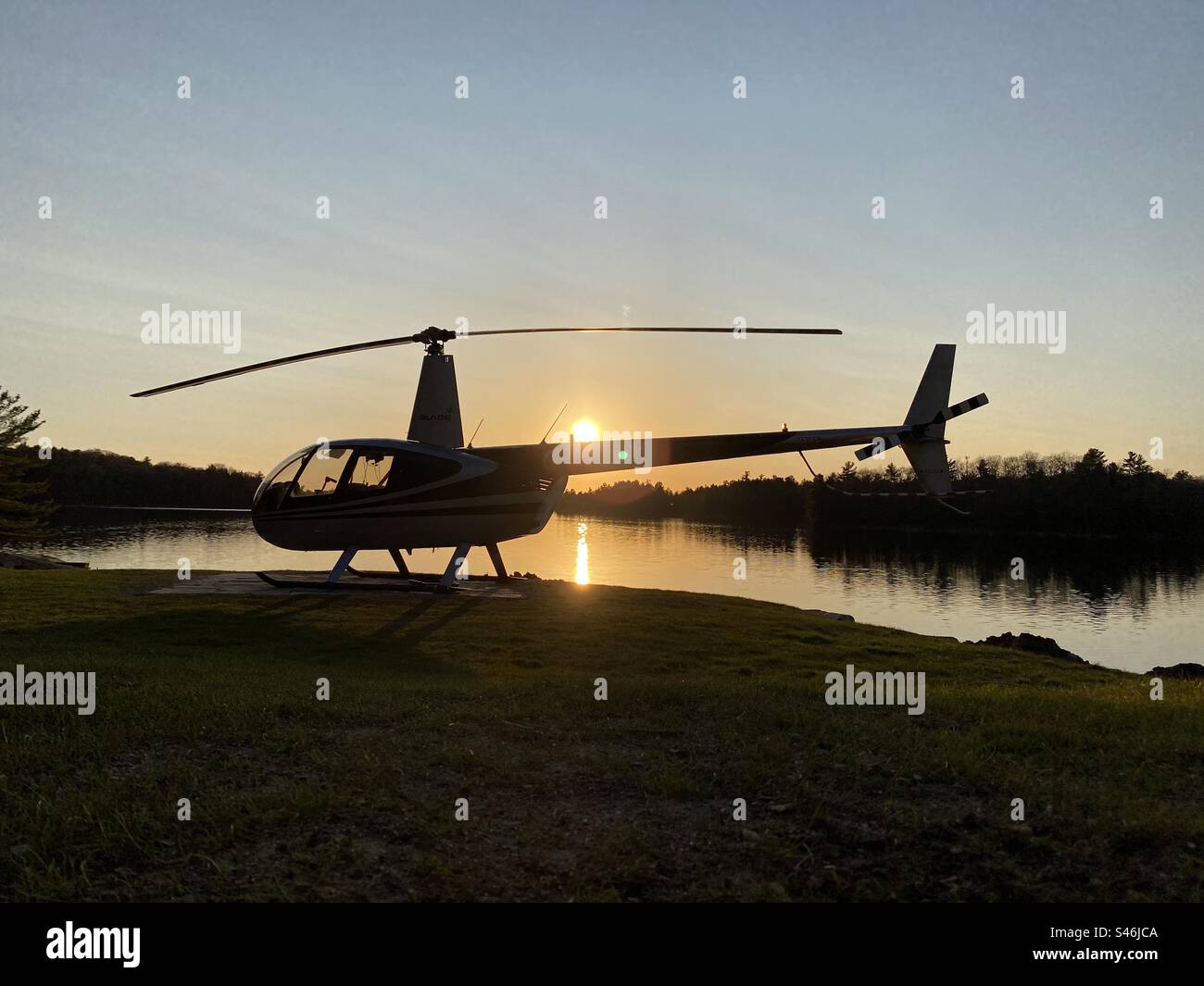 Helicopter park by lake at sunset Stock Photo - Alamy