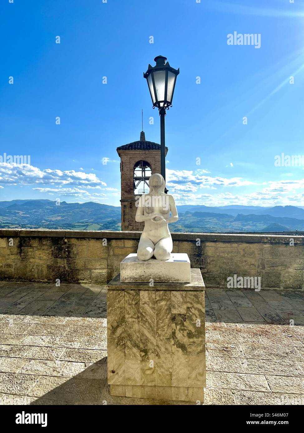Statue “Selene” sits on a pathway in front of the bell tower of chiesa ...