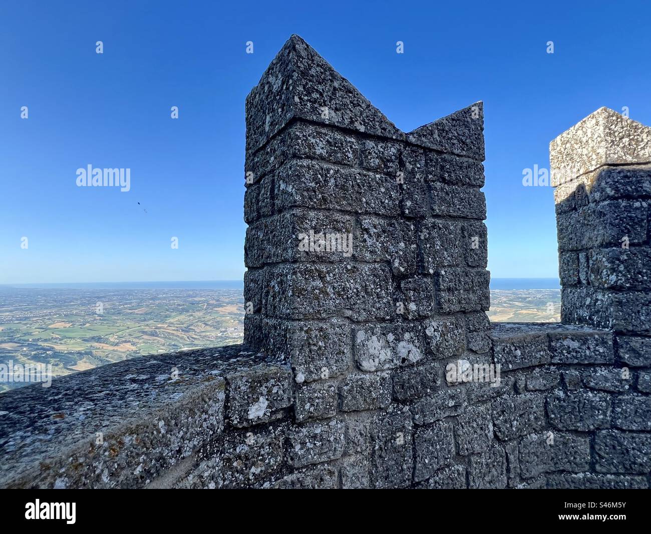 Stone fortress wall of Guaita Tower in San Marino on a clear summer day ...