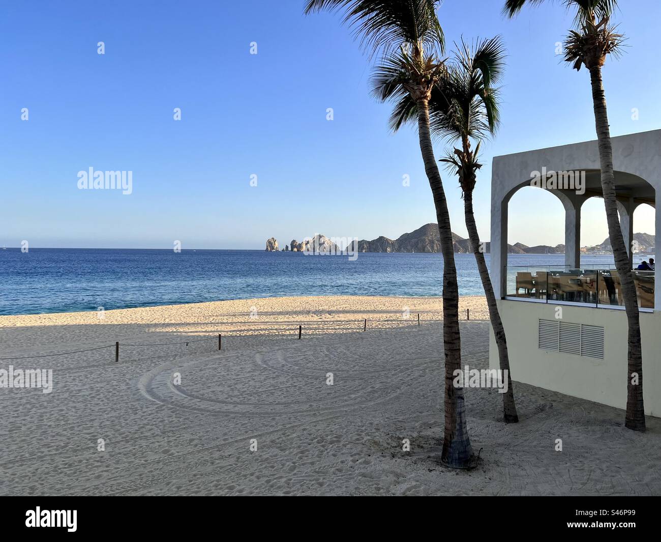 A beautiful tranquil beach, with palm trees with the arches of Cabo San ...