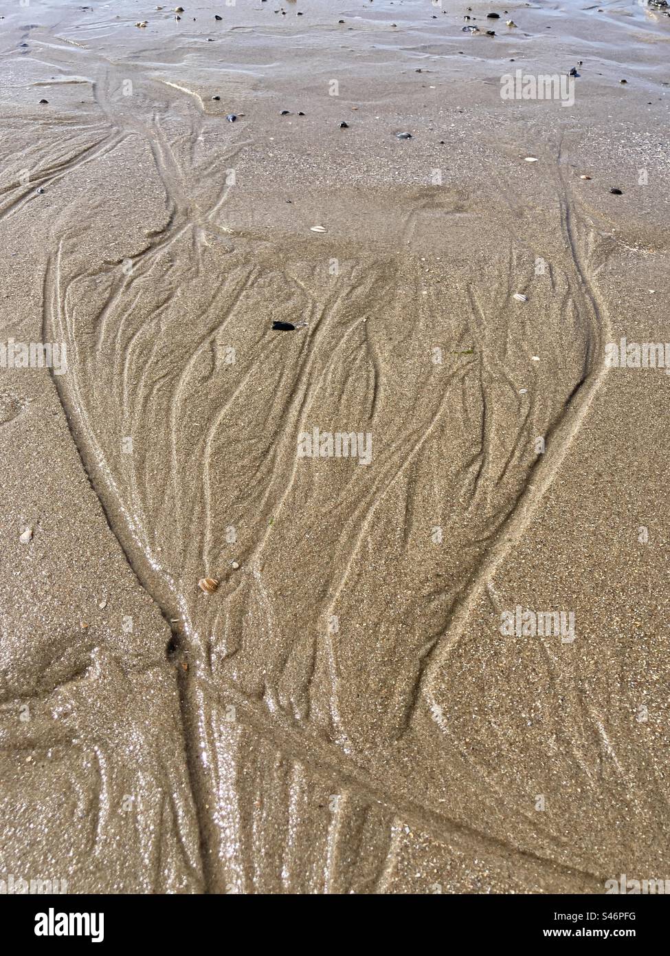 Wavy lines in sand on beach created by water running off Stock Photo ...