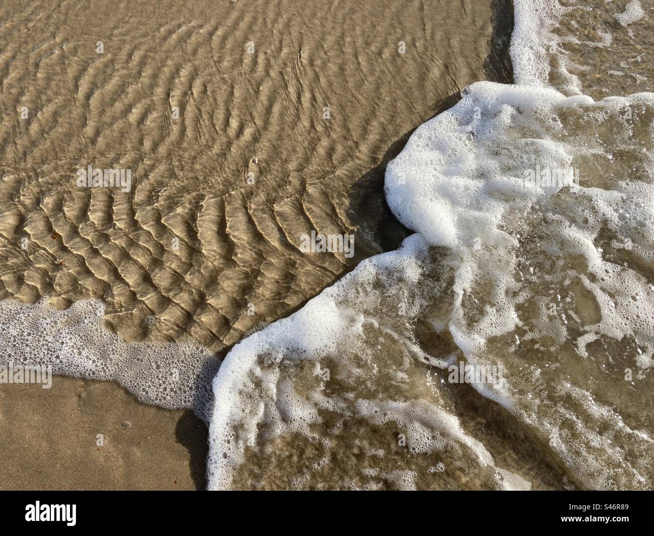 Wavy lines in sand on beach created by water running off Stock Photo ...
