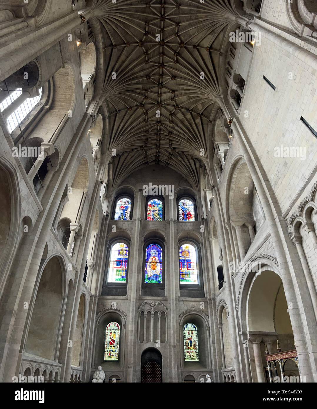 Interior stone arches and columns in Norwich cathedral with stained ...