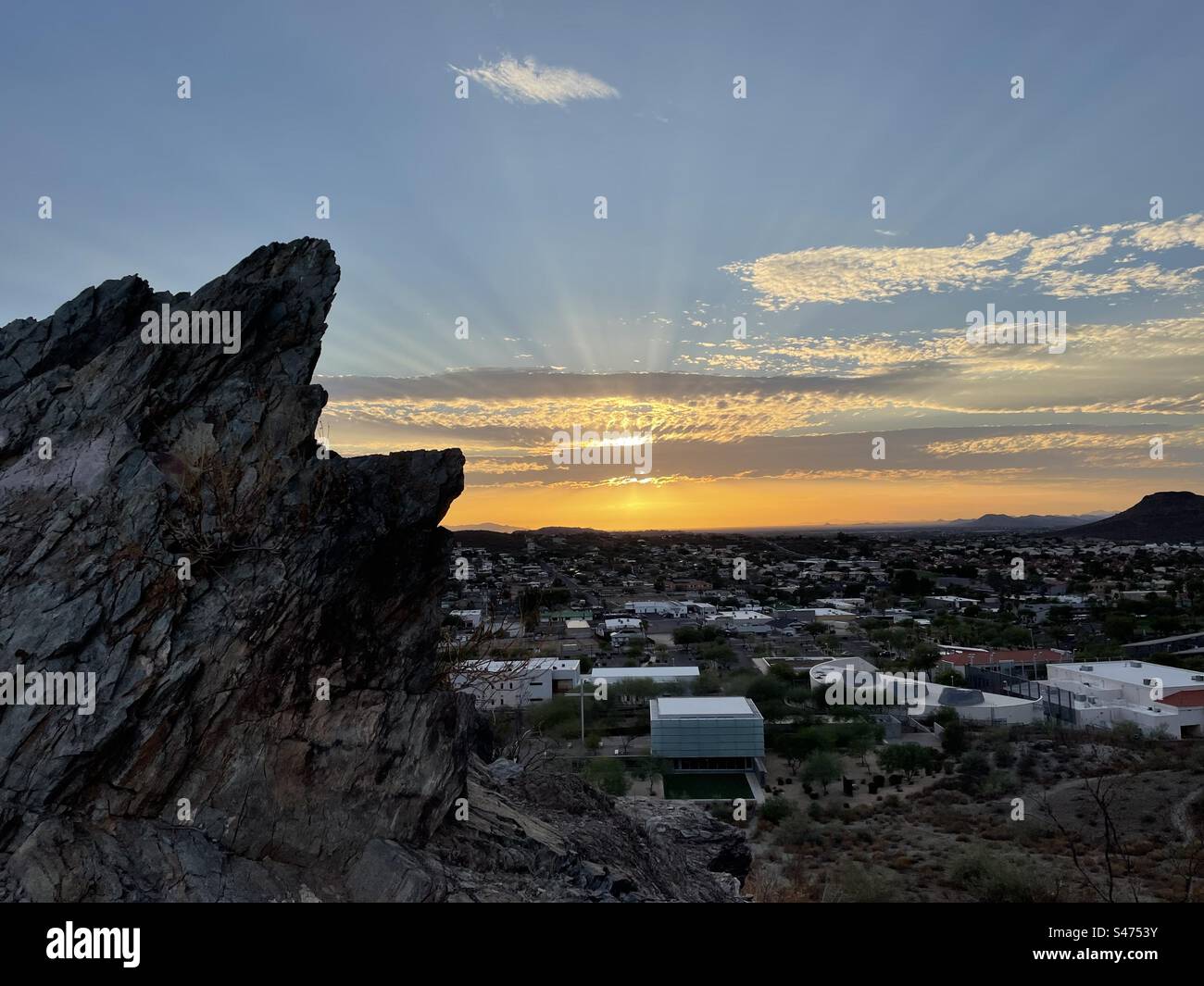 Sun rays fan from golden sunset in twilight blue sky, bands of purple ...