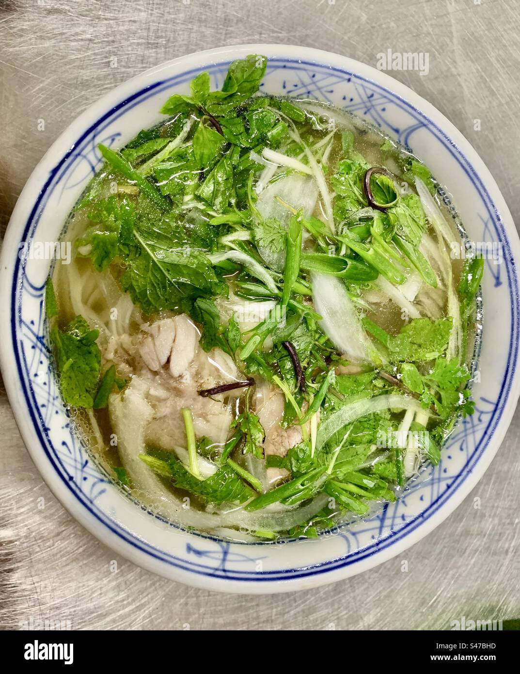 Typical Vietnamese Pho - a beef noodle soup with herbal leaves on top ...