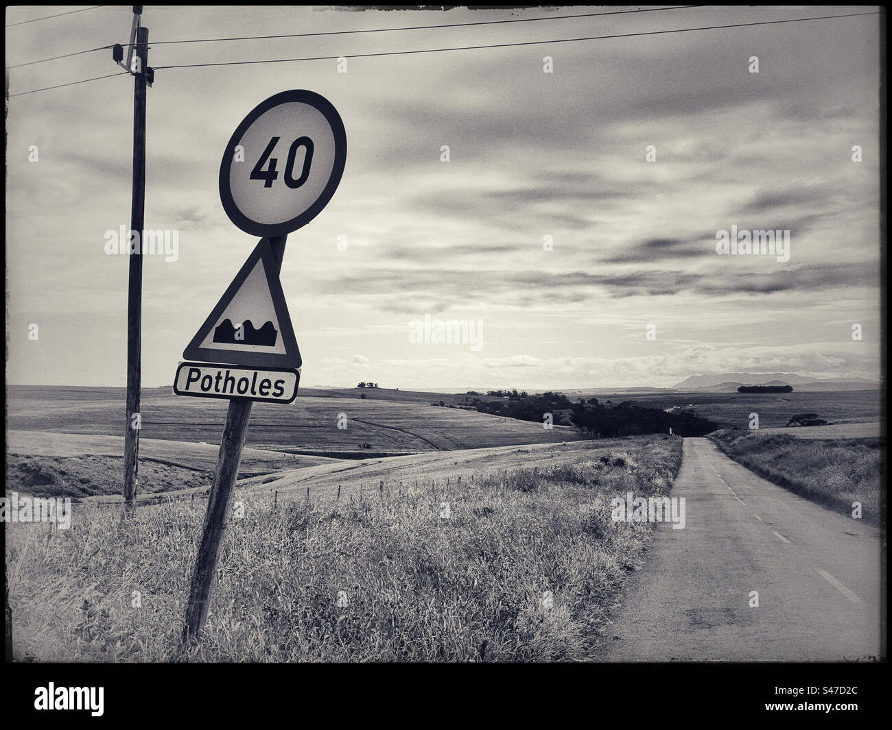 Potholes road sign in the countryside Stock Photo - Alamy