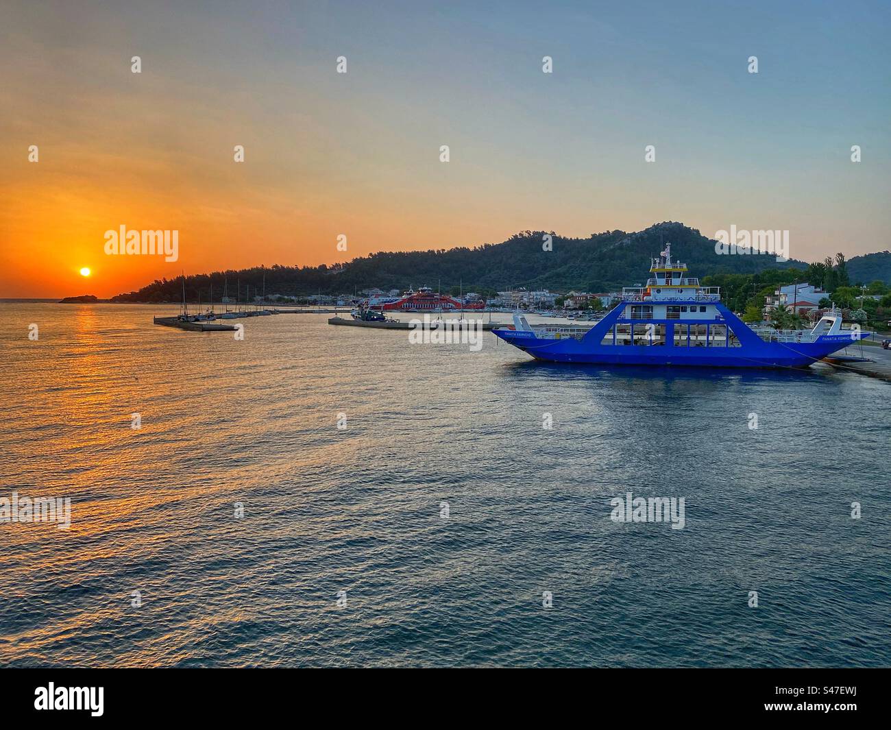 Sunrise with blue ferry boat in Limenas Harbor on Thassos island in ...