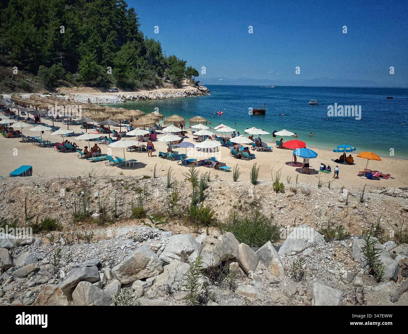 Marble beach with sun umbrellas, marble sands and stones on Thassos ...