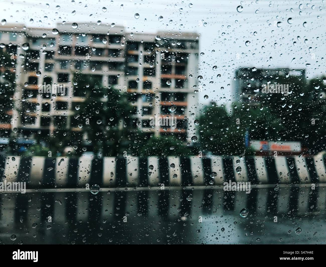 Buildings seen from a car window full of water droplets Stock Photo - Alamy