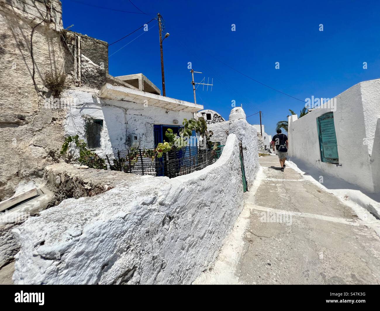 Walking a narrow street of Akrotiri village on Santorini island in the ...