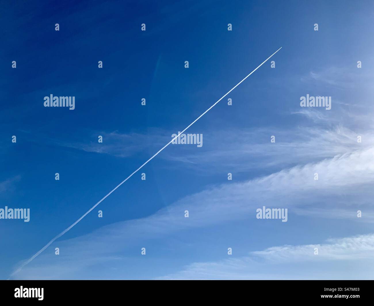 White contrail lines of aeroplane in blue sky Stock Photo - Alamy